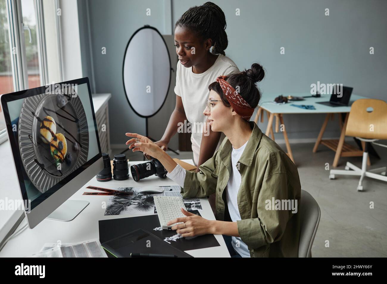 Side view portrait of two female photographers discussing images on ...