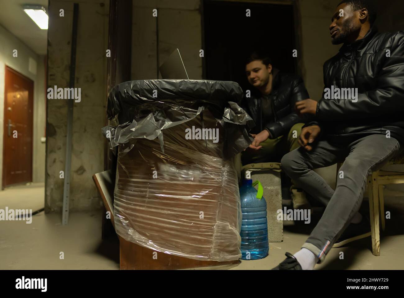 Basement with caucasian guy and black guy sitting and having a talk ...