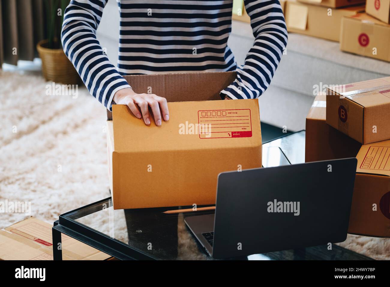 Online merchandising business idea, a beautiful girl is packing the ...