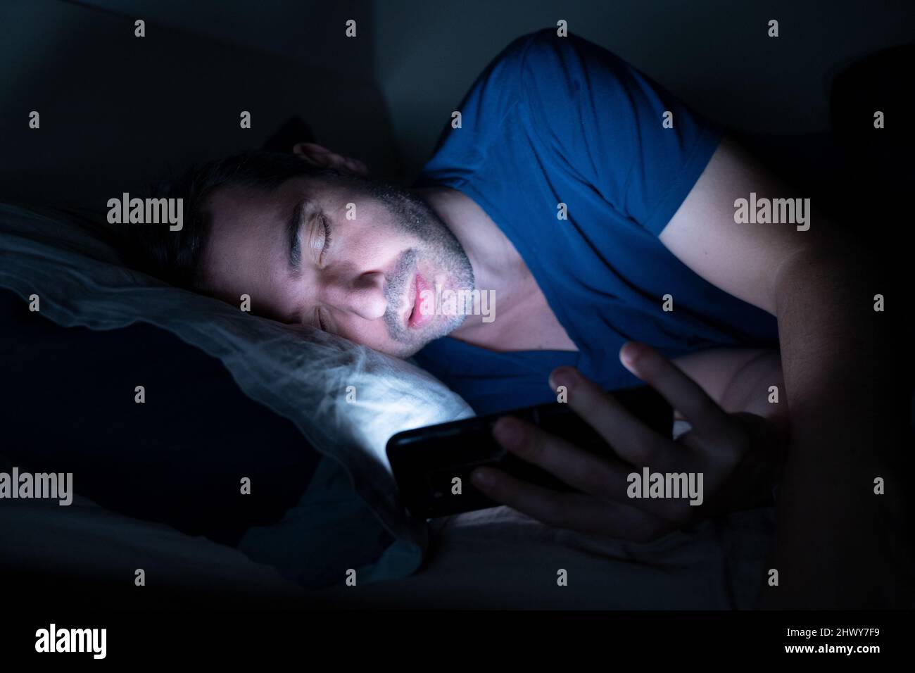 One man falling asleep using mobile phone at night Stock Photo - Alamy