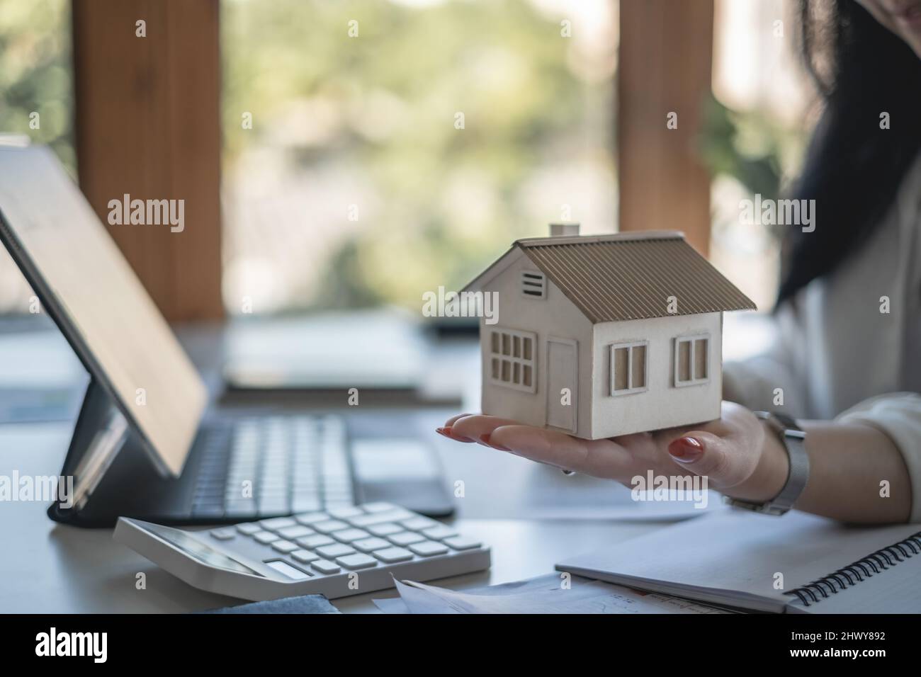 A woman holding and checking house model .Real Estate House Appraisal ...