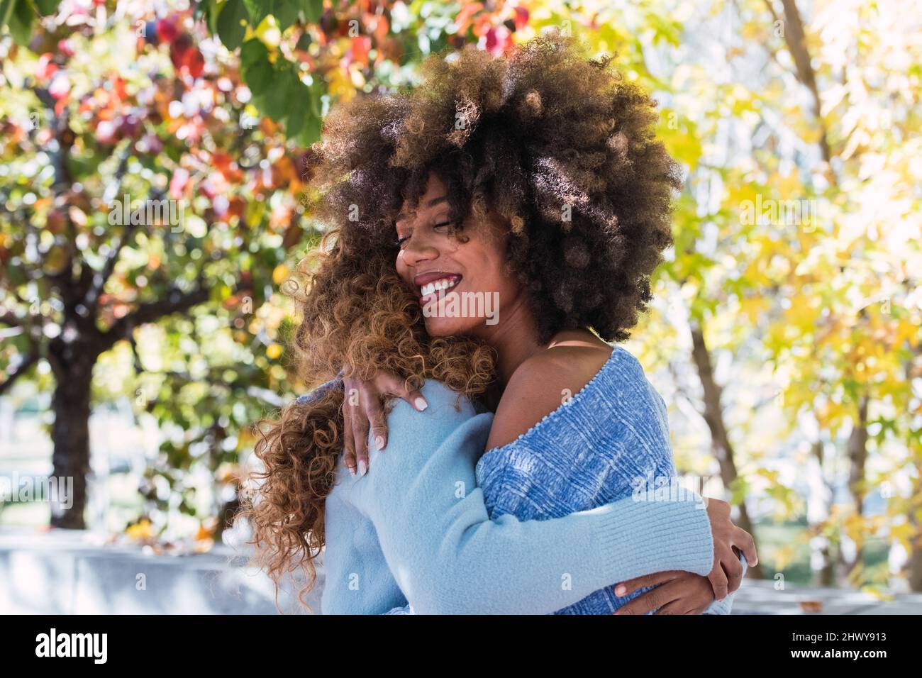 Two female afro american happy best friends hugging each other and ...