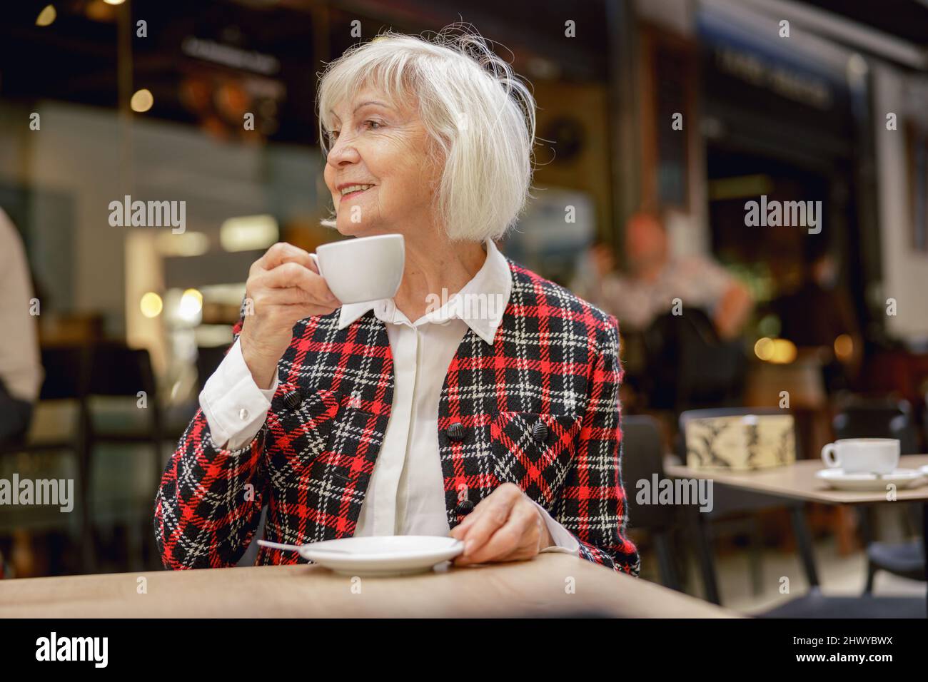 Good looking pensioner female relaxing at street cafe Stock Photo - Alamy