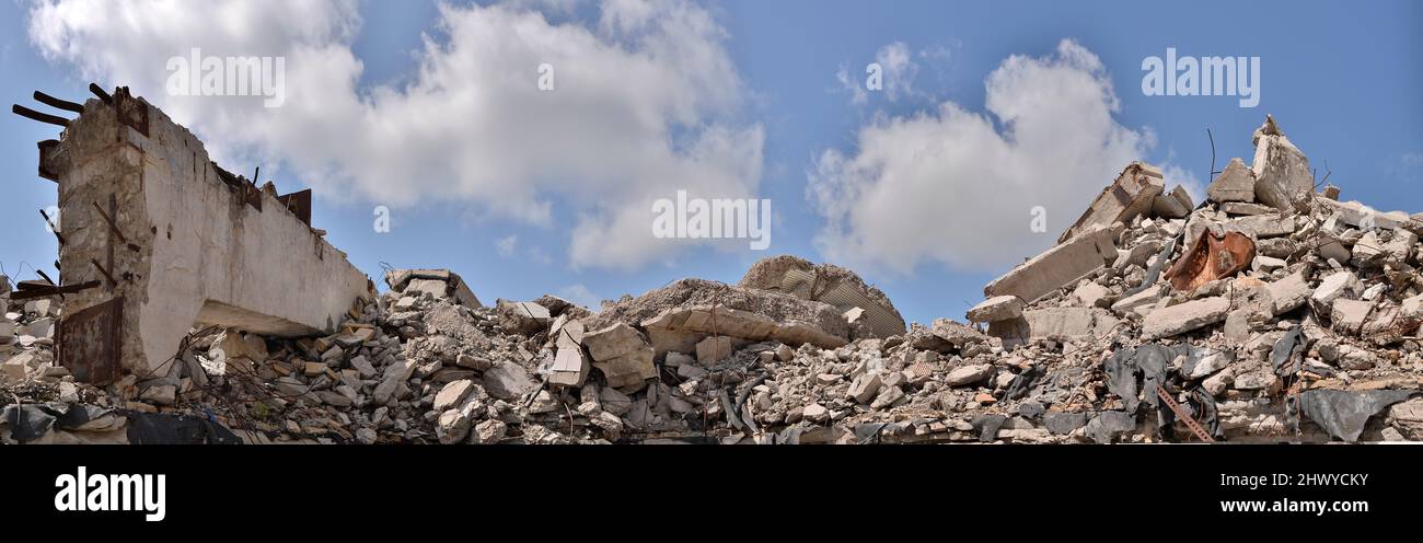 A pile of concrete gray debris of a destroyed building with a huge beam ...