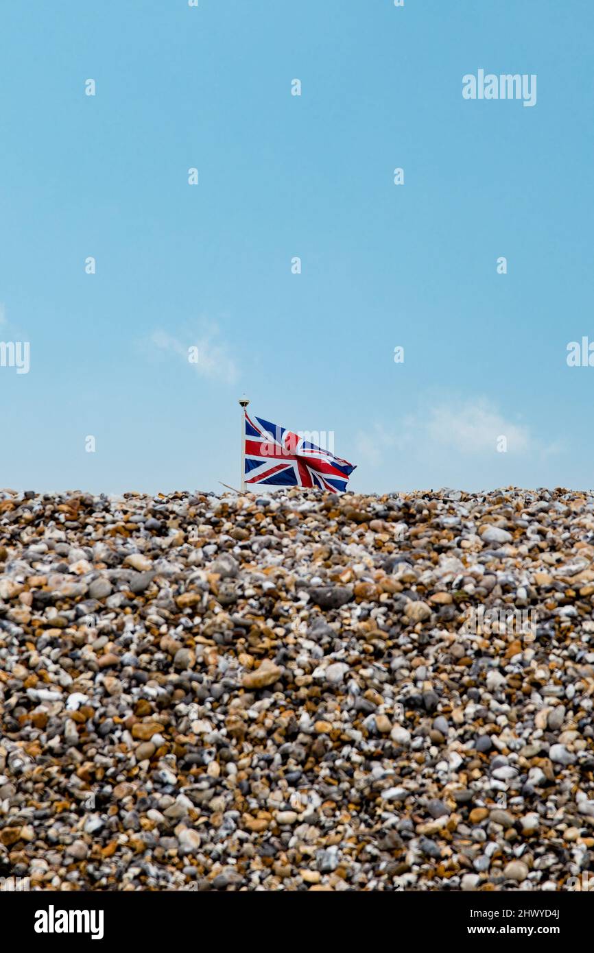 British Union Jack flag flying above a pebble beach Stock Photo - Alamy