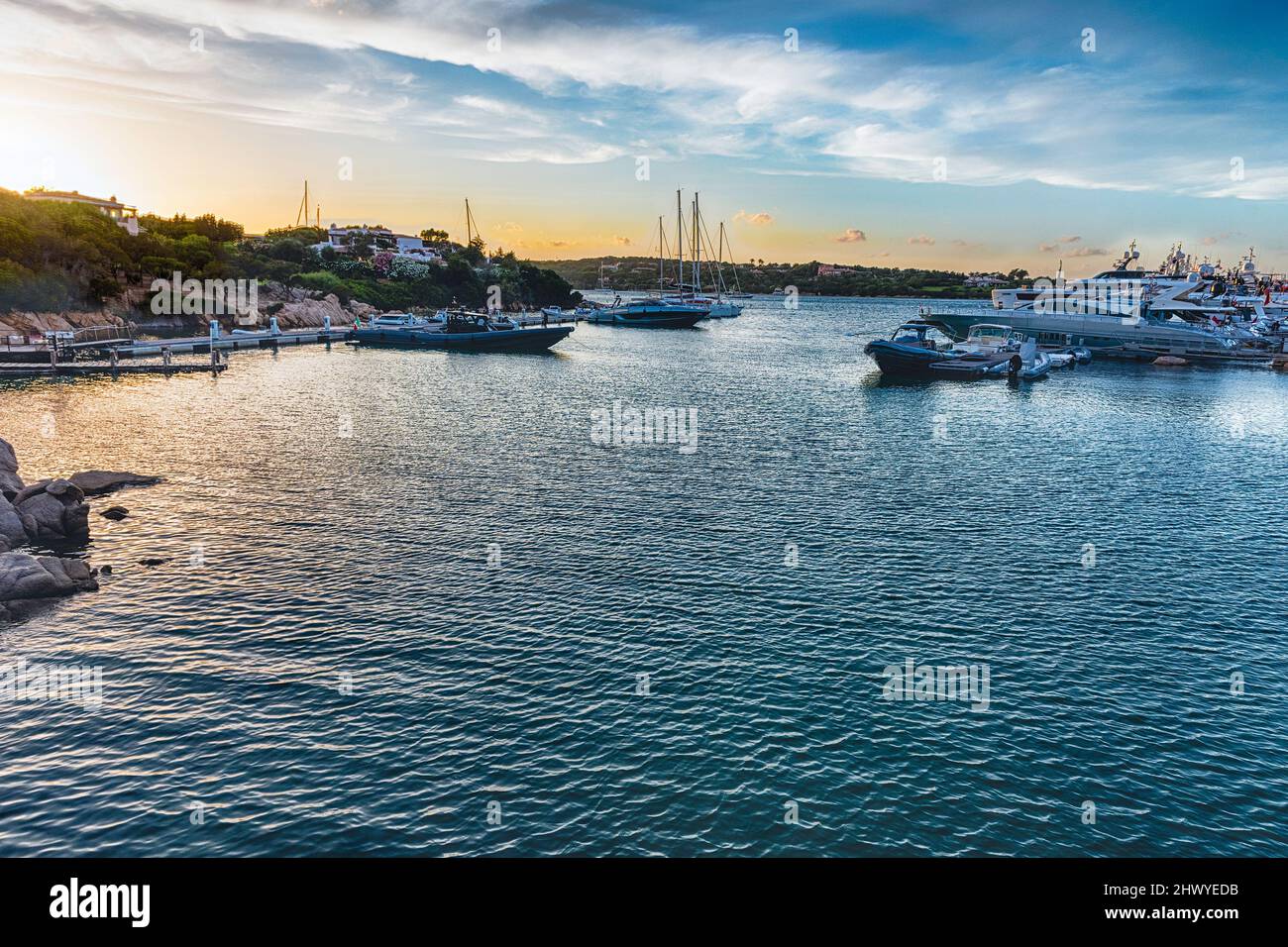 Sunset at the harbor with luxury yachts in Porto Cervo, Sardinia, Italy ...