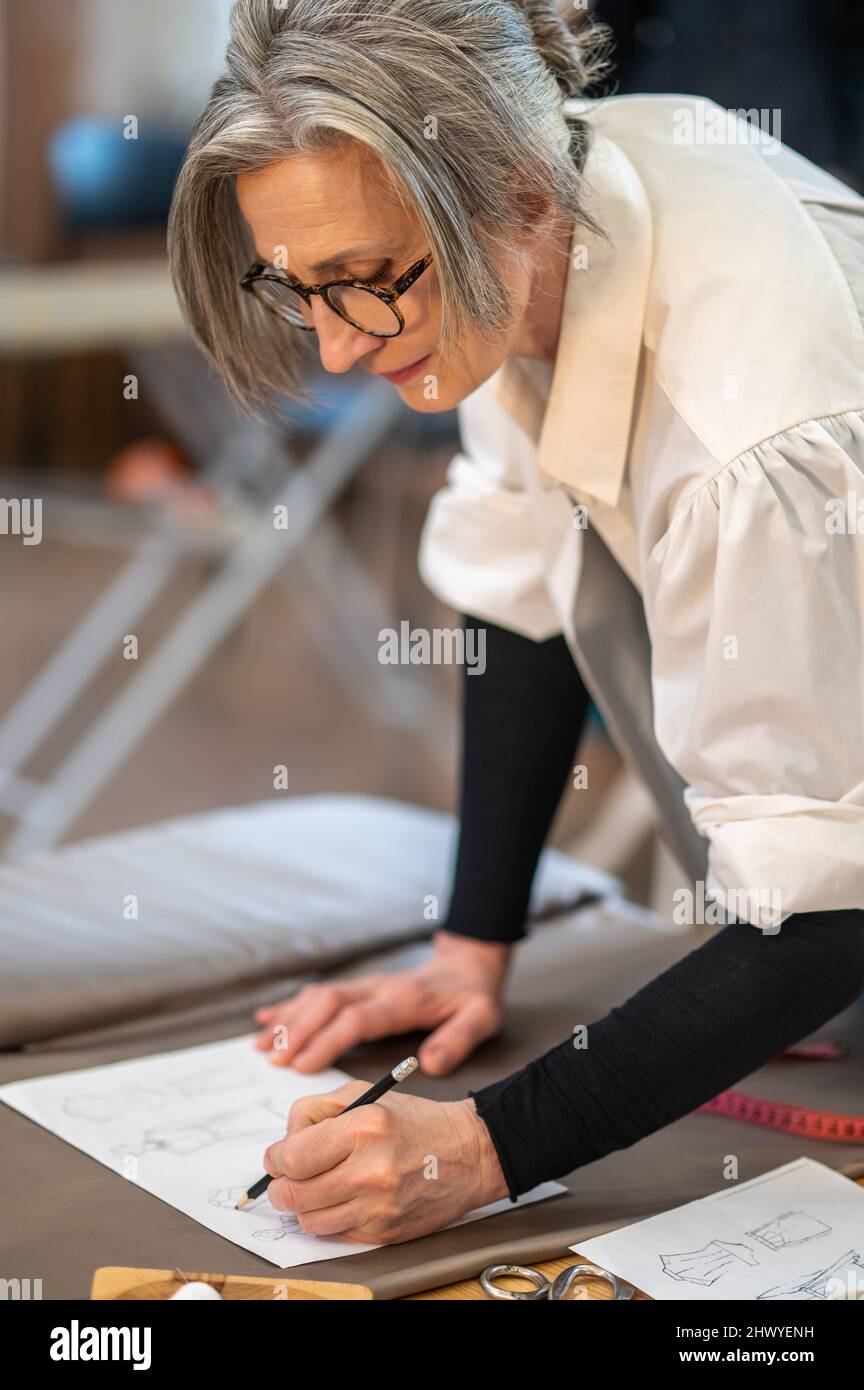 Woman standing over table drawing sketch Stock Photo - Alamy