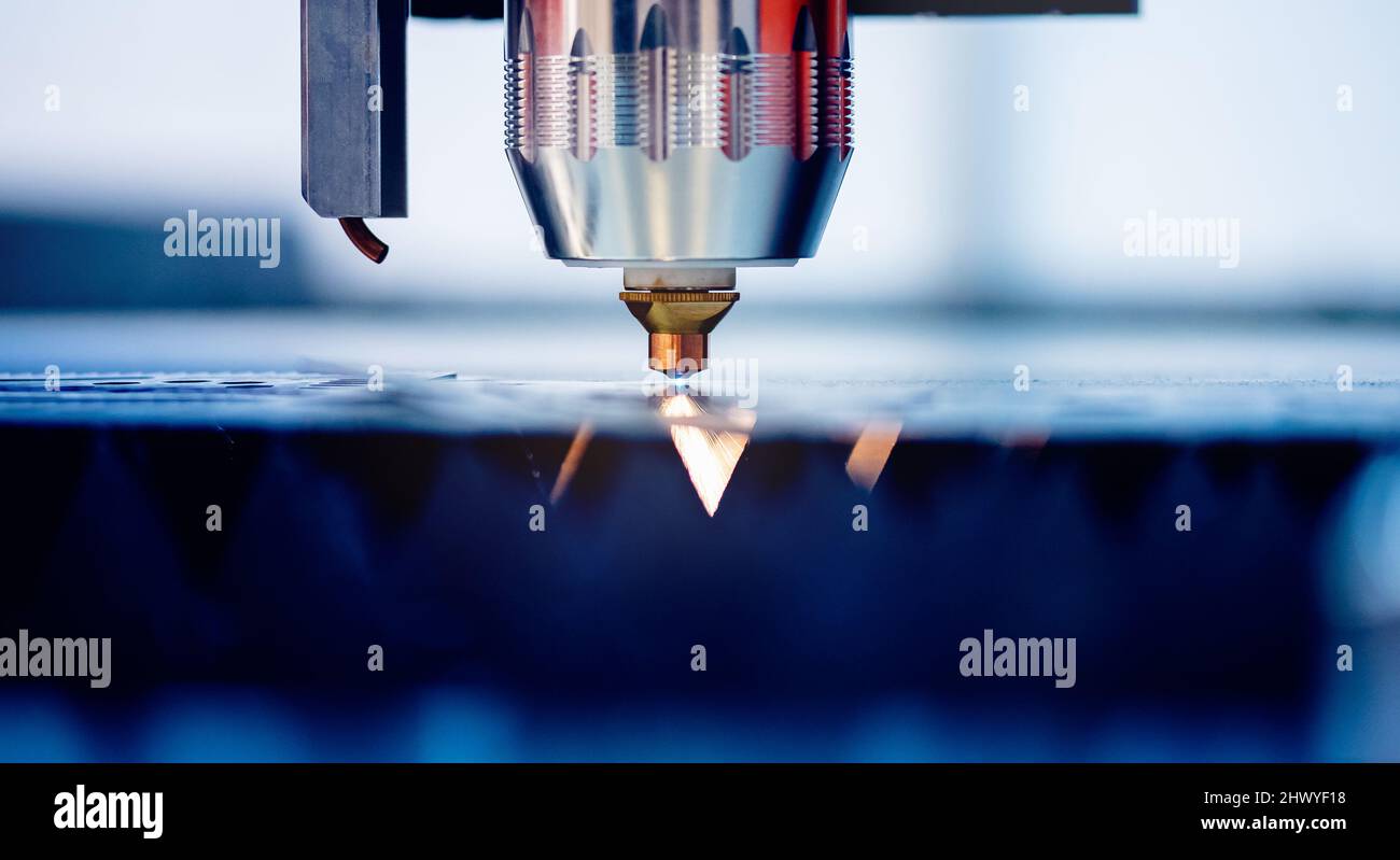 Blue color Laser CNC cut of metal with light spark, technology modern ...