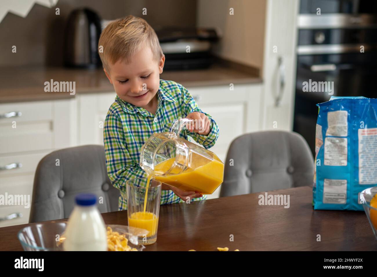 Child pouring a fruit juice from the jug Stock Photo - Alamy