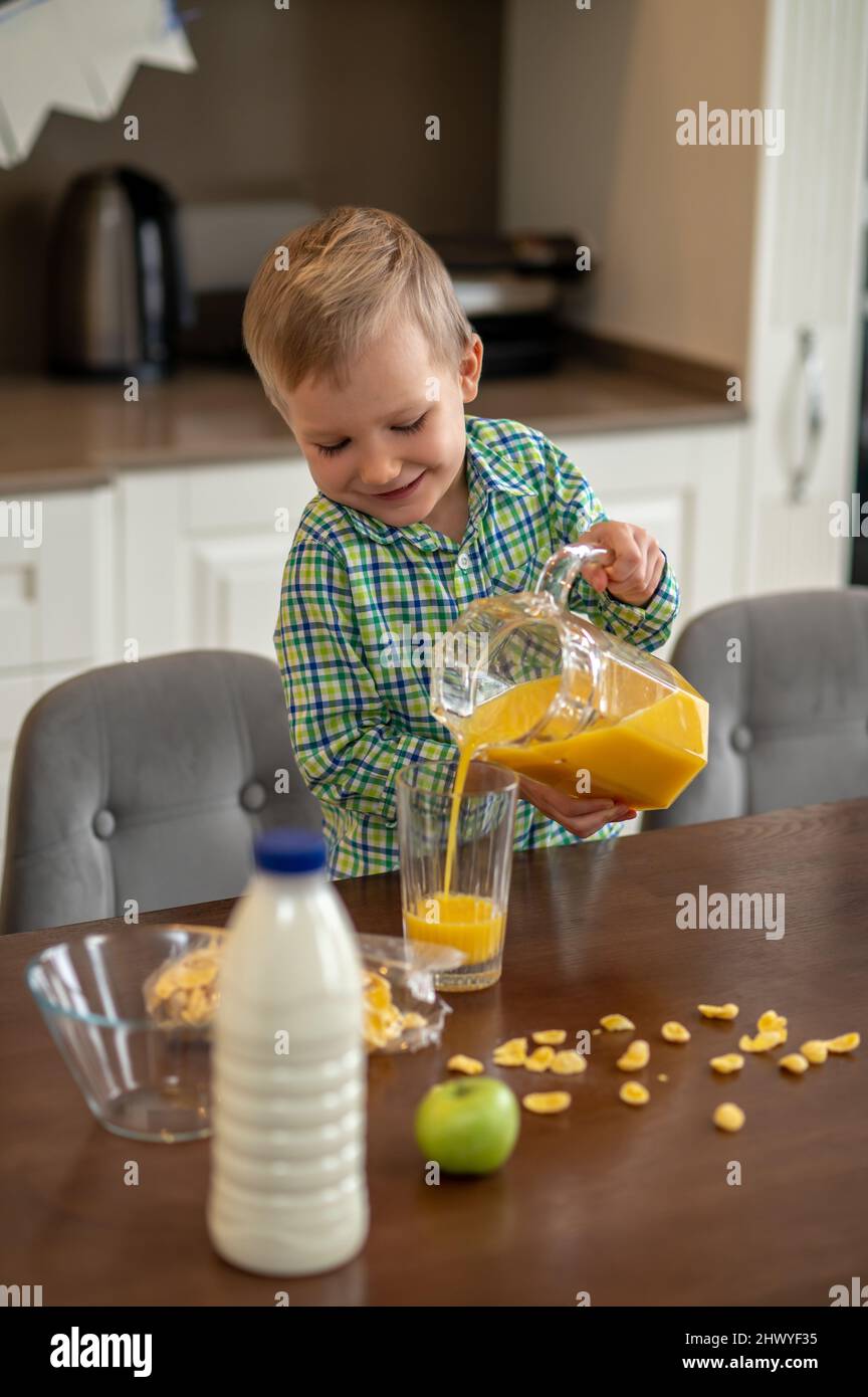Smiling boy pouring a citrus drink from the pitcher Stock Photo - Alamy