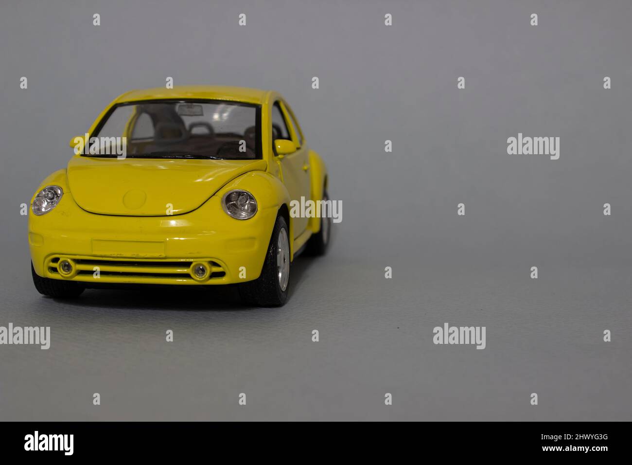 Yellow toy car on a gray background, front view Stock Photo - Alamy
