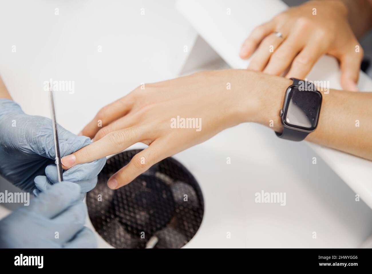 Man gets professional manicure care for nail in spa salon, white color ...