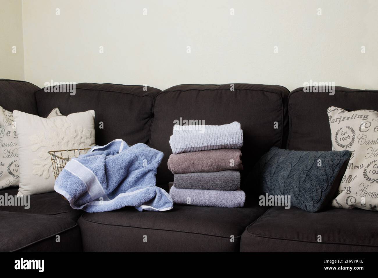folded towels and cushions on sofa Stock Photo - Alamy