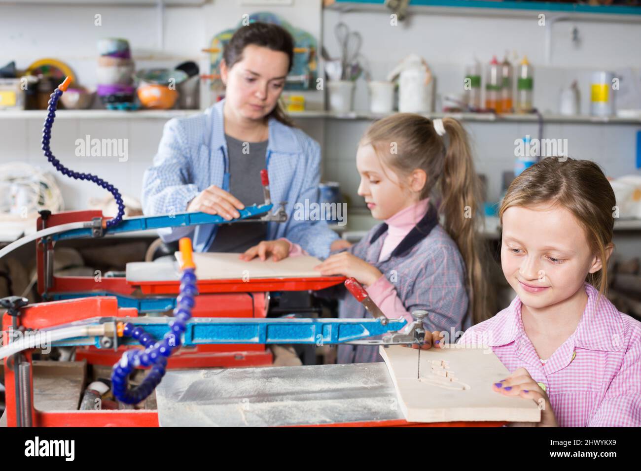 Happy girls practicing skills at wood carving Stock Photo - Alamy