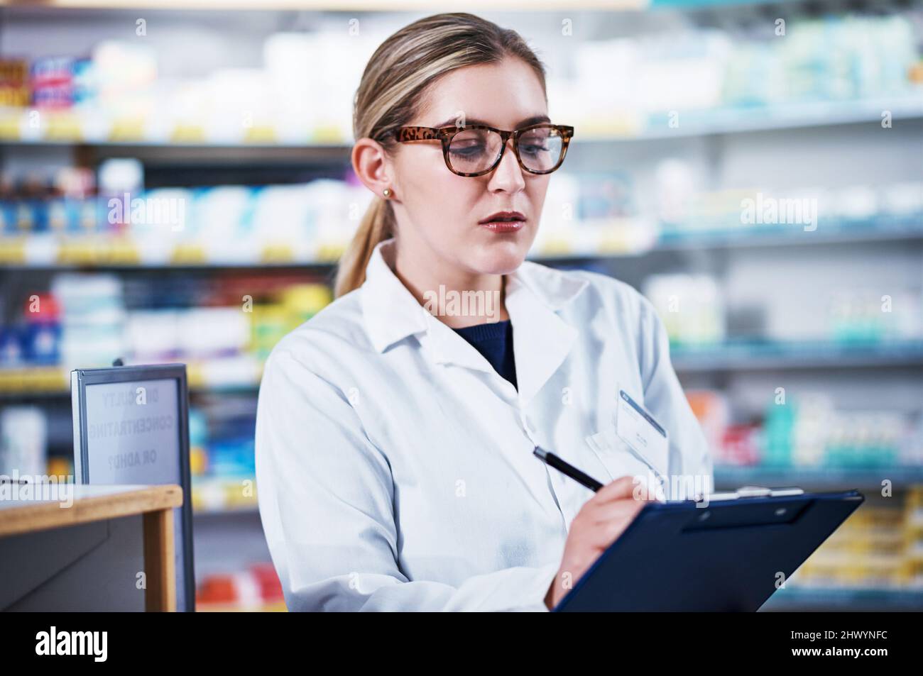 Taking notes of all the medical stock in store. Shot of a young ...