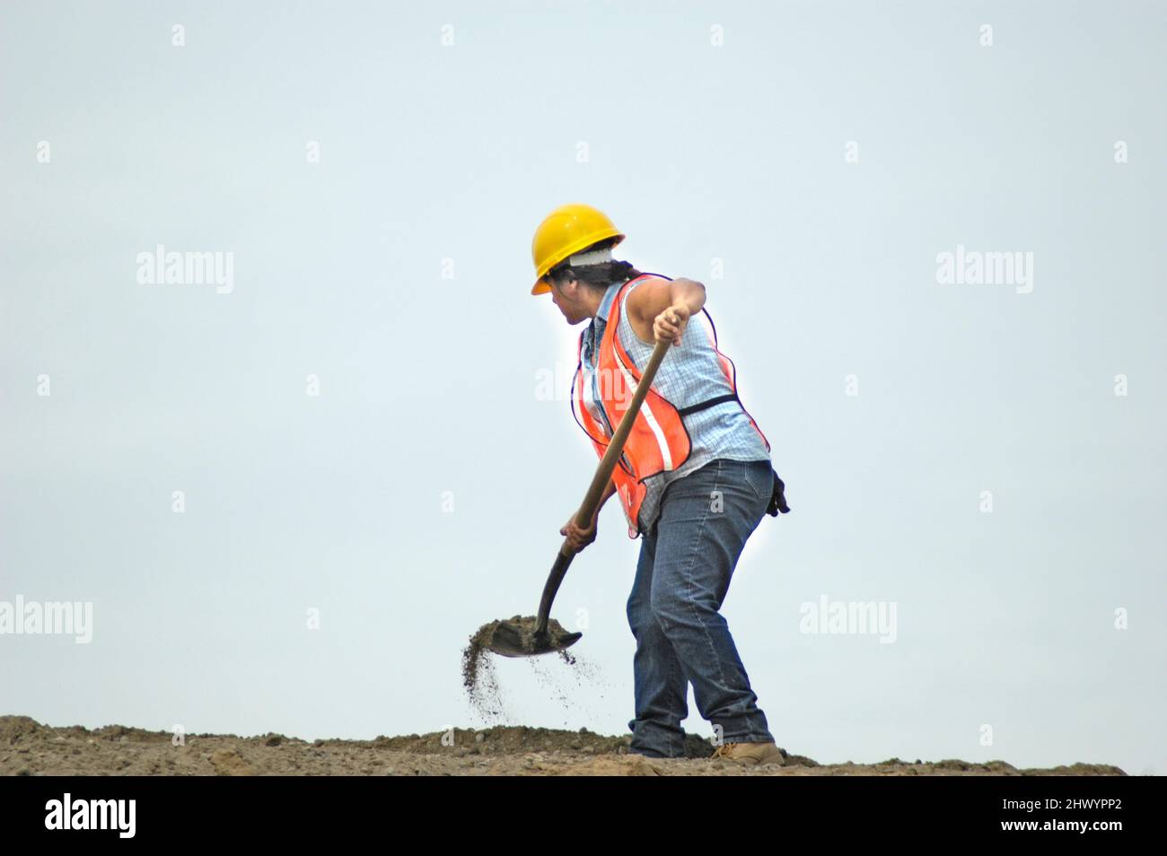 Highway construction site with women working hard labor with shovels ...