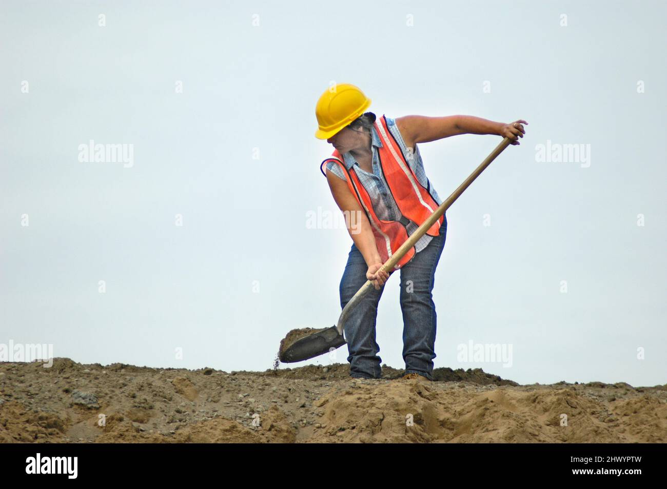 Highway construction site with women working hard labor with shovels ...