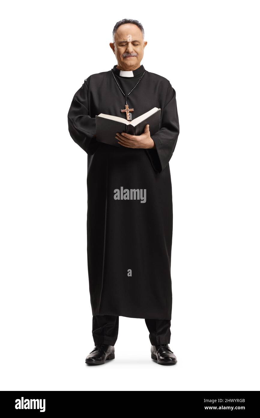 Full length portrait of a mature priest standing and reading the bible ...