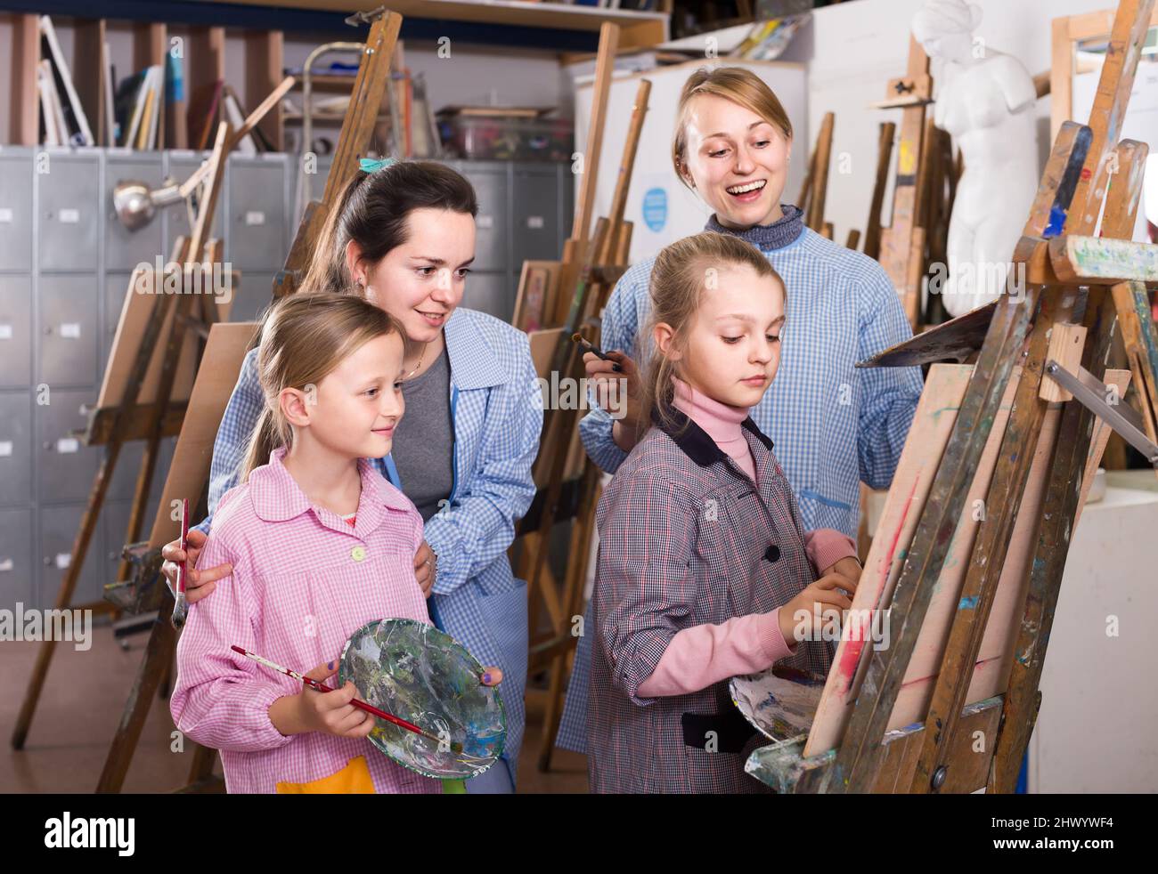 Skillful young students looking at progress of fellow student during ...