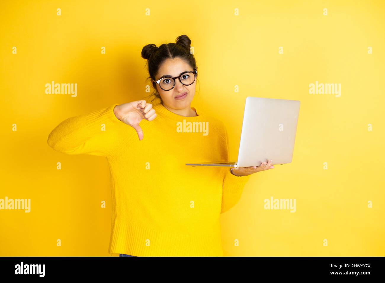 Young brunette woman working using computer laptop over yellow ...