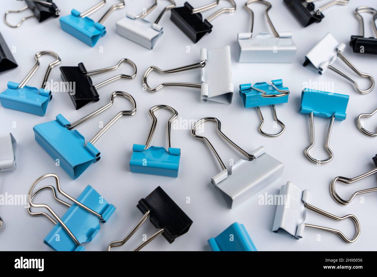 Cheerful background of colored stationery clips on a white background ...