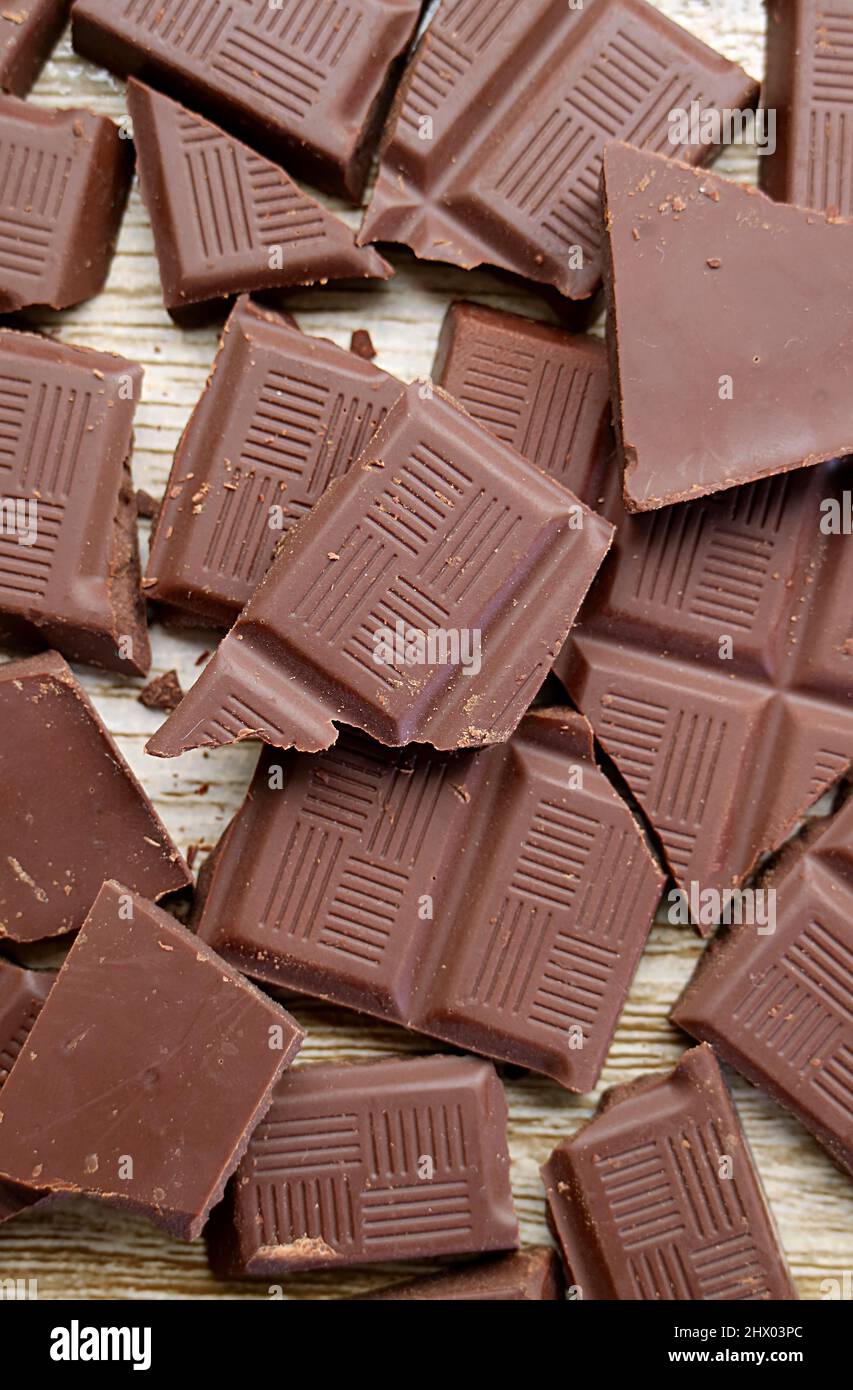 Heap of cracked chocolate bar scattered on wooden background Stock ...