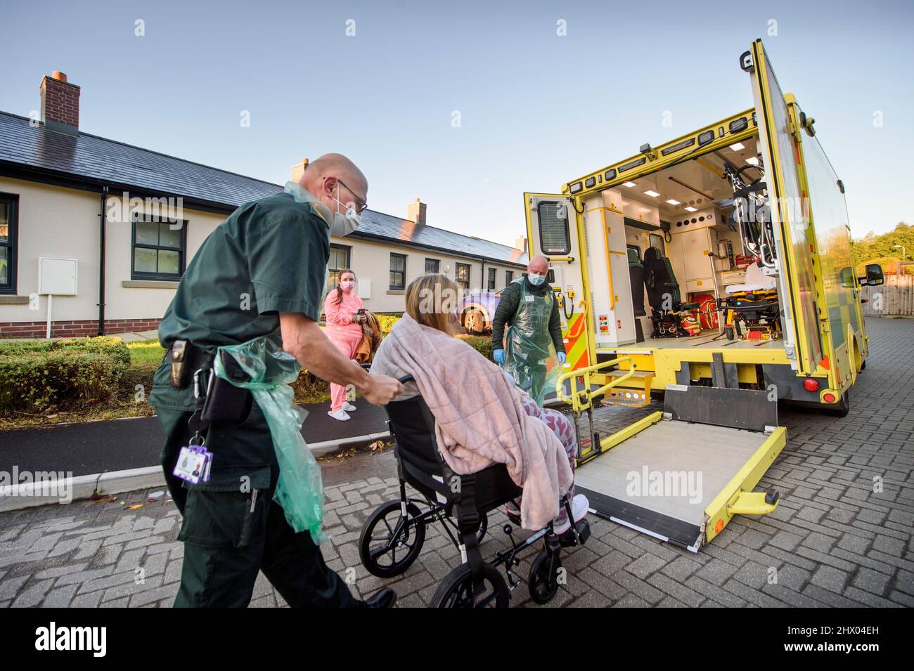 Paramedics move a patient to their ambulance after examining the ...