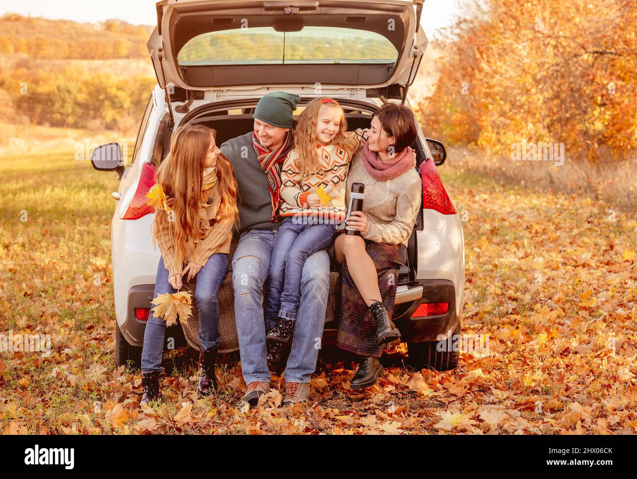 Family sitting in car trunk Stock Photo - Alamy