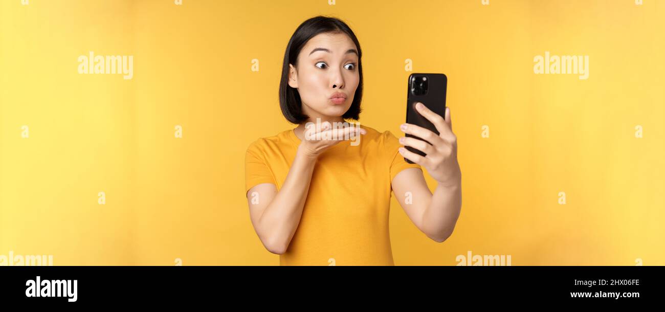 Image of happy, beautiful asian girl video chatting, talking on ...