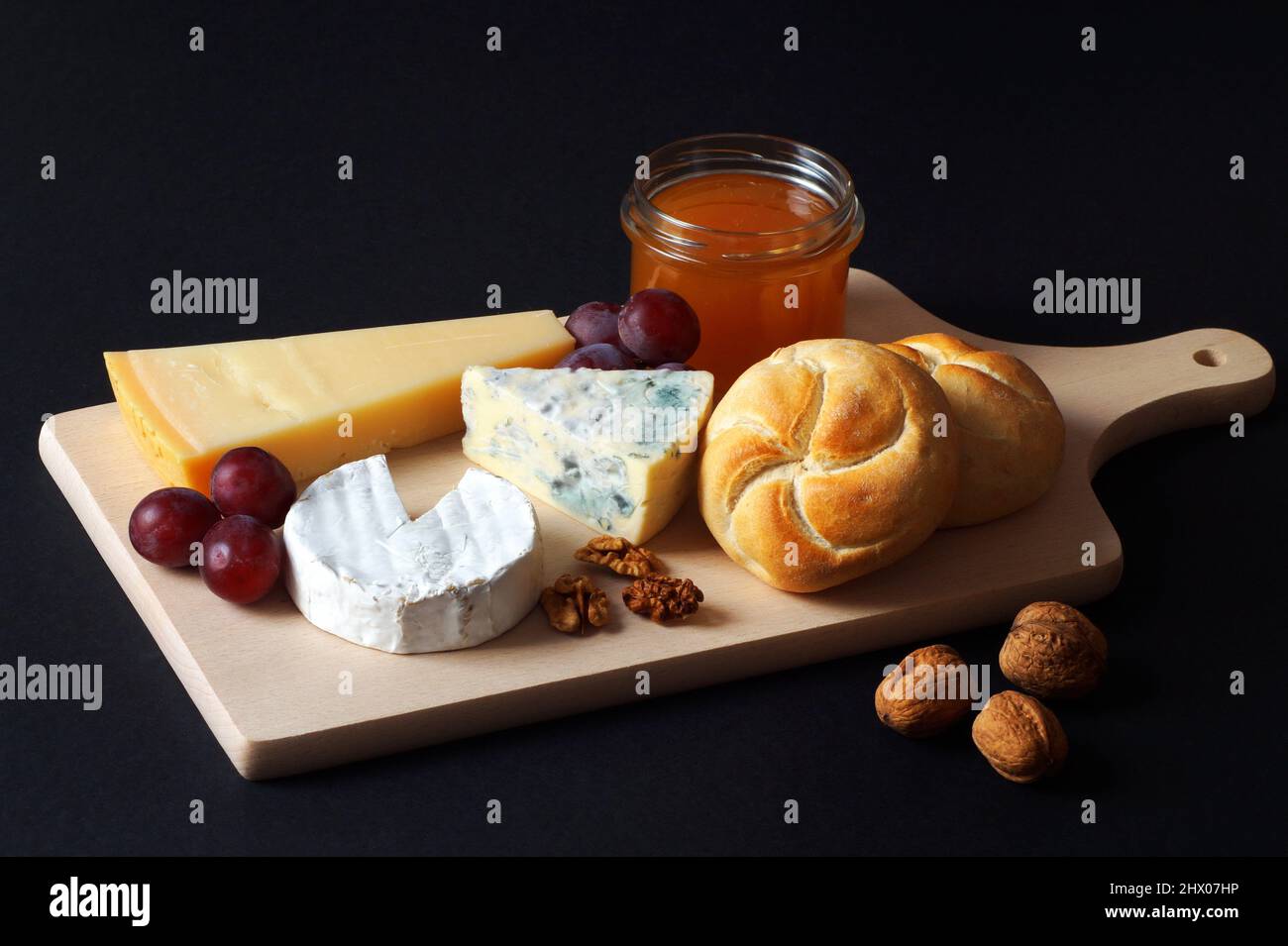 Three types of cheese - camembert, blue and parmesan lie on the board ...