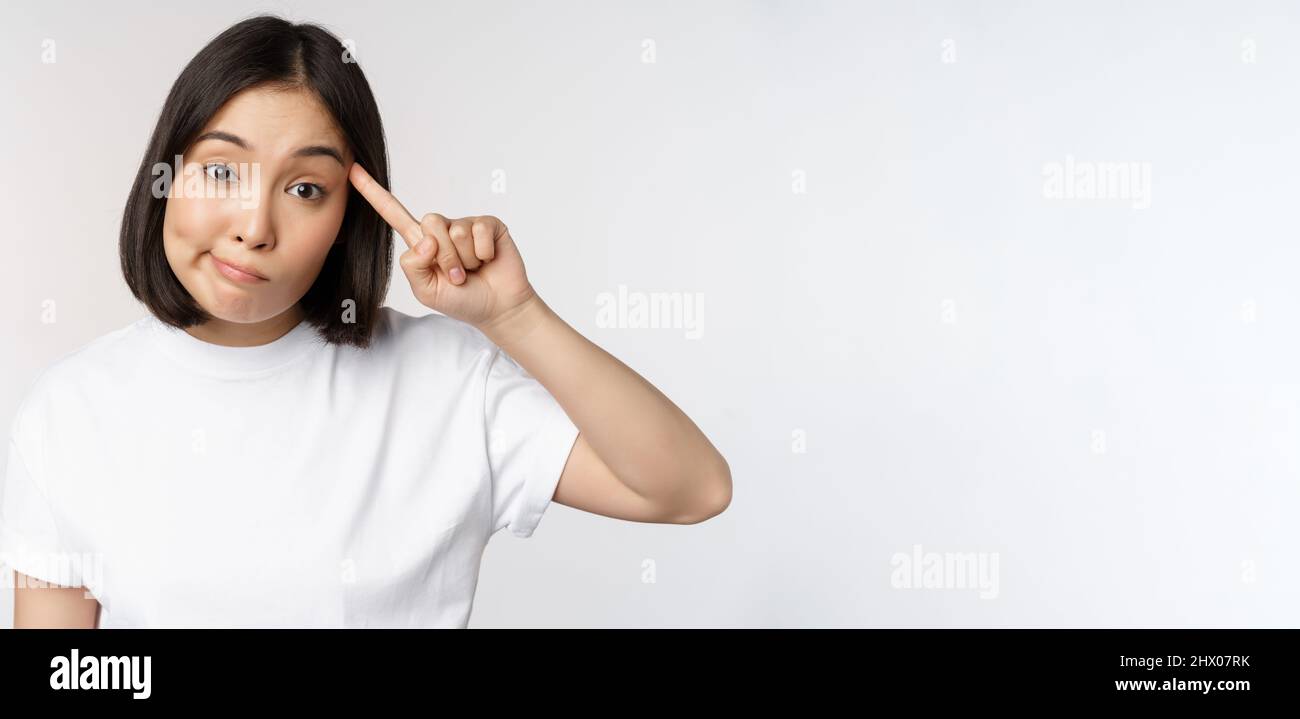 Are you crazy. Young asian woman roll finger on head, mocking someone ...