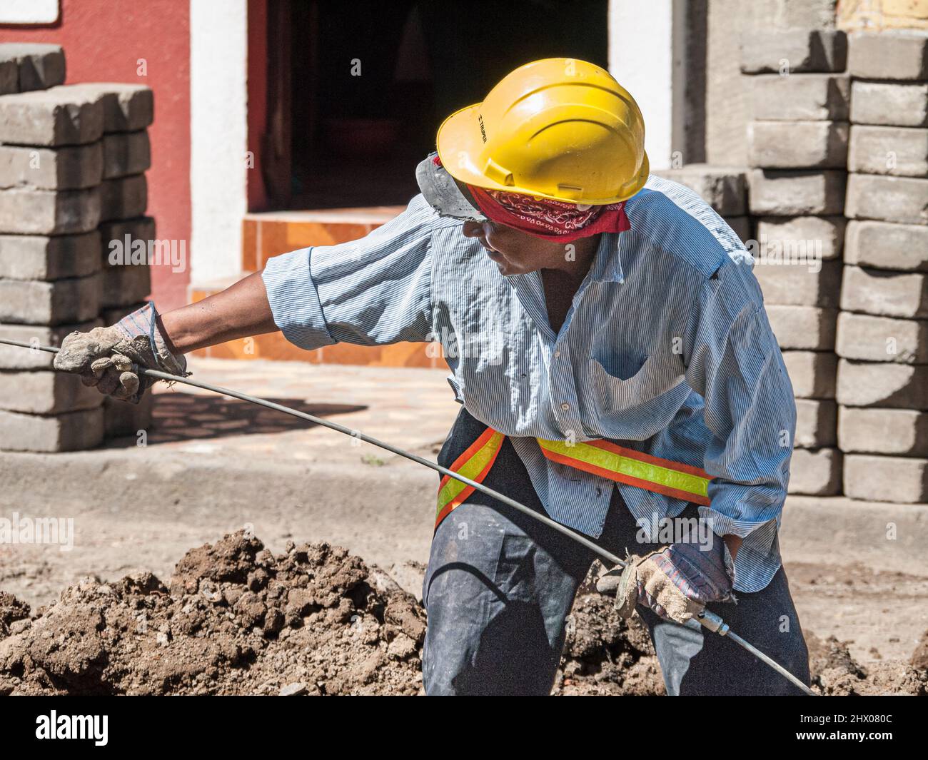 Man pulling wire rope guiding pipe in a sewage system renovation in ...