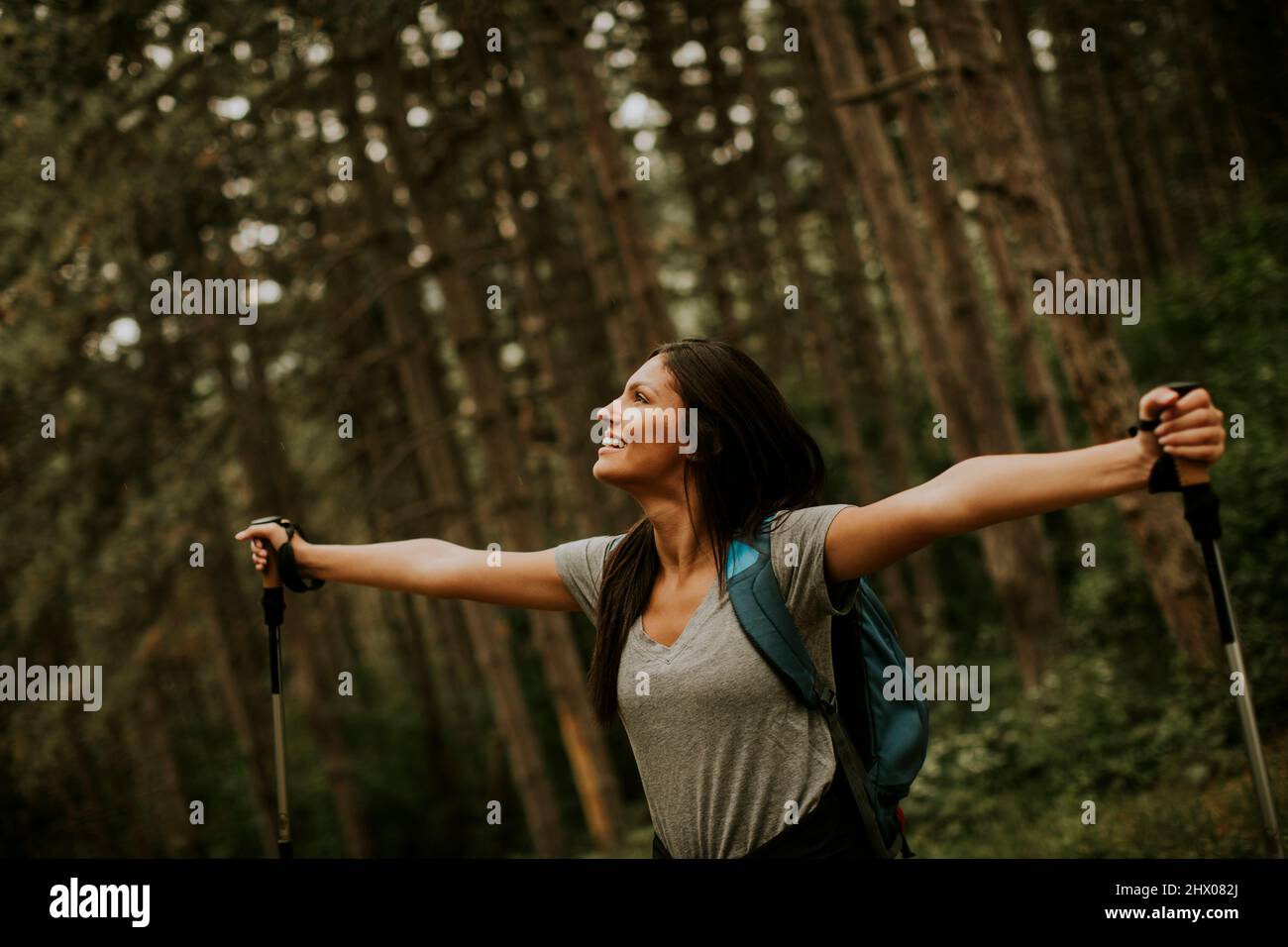 Pretty young female backpacker woman enjoying green beautiful forest ...