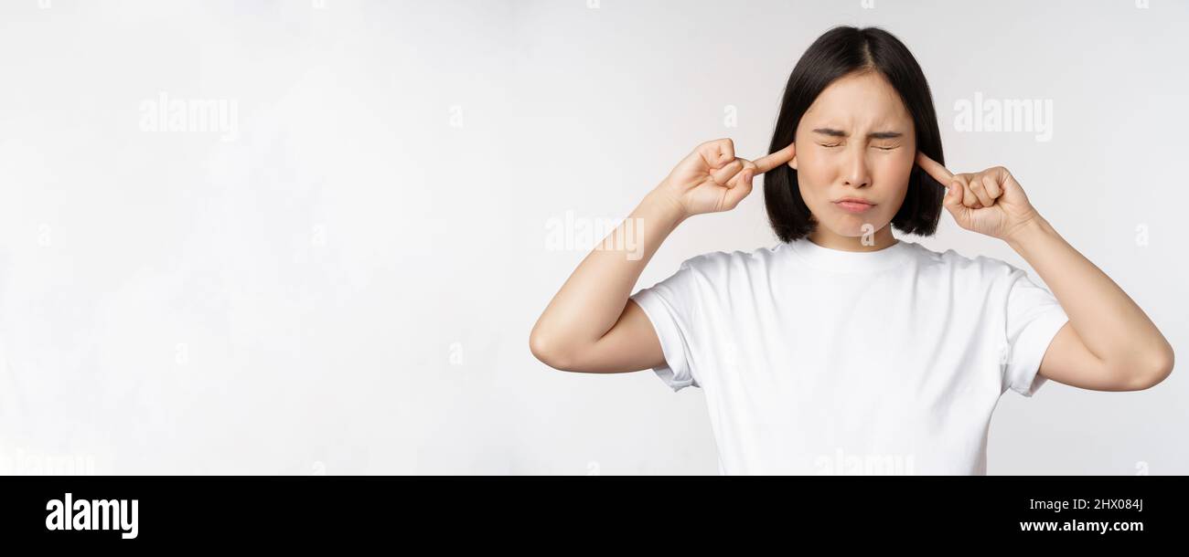 Portrait of asian woman shut ears and feeling discomfort from loud ...