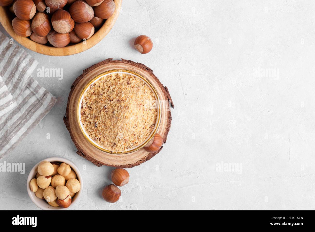 Raw Organic Ground Hazelnut Flour in a Bowl with whole nuts on grey ...