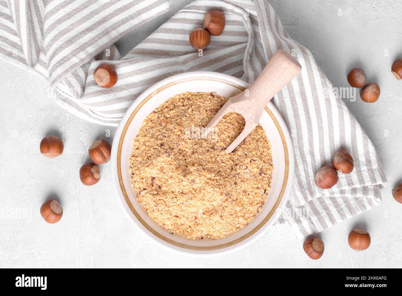 Raw Organic Ground Hazelnut Flour in a Bowl with whole nuts on grey ...