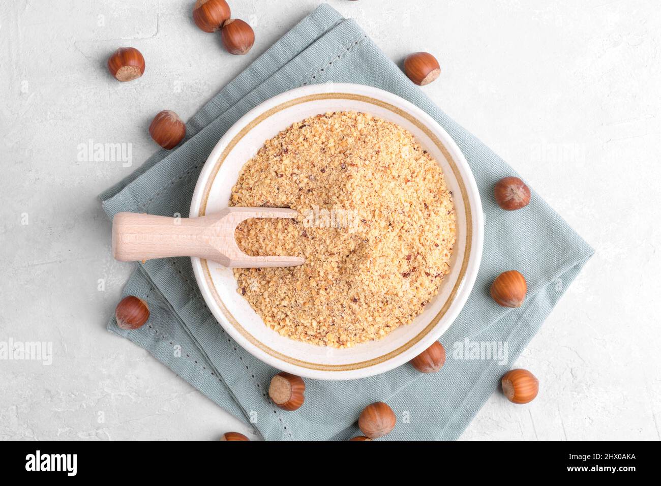 Raw Organic Ground Hazelnut Flour in a Bowl with whole nuts on grey ...