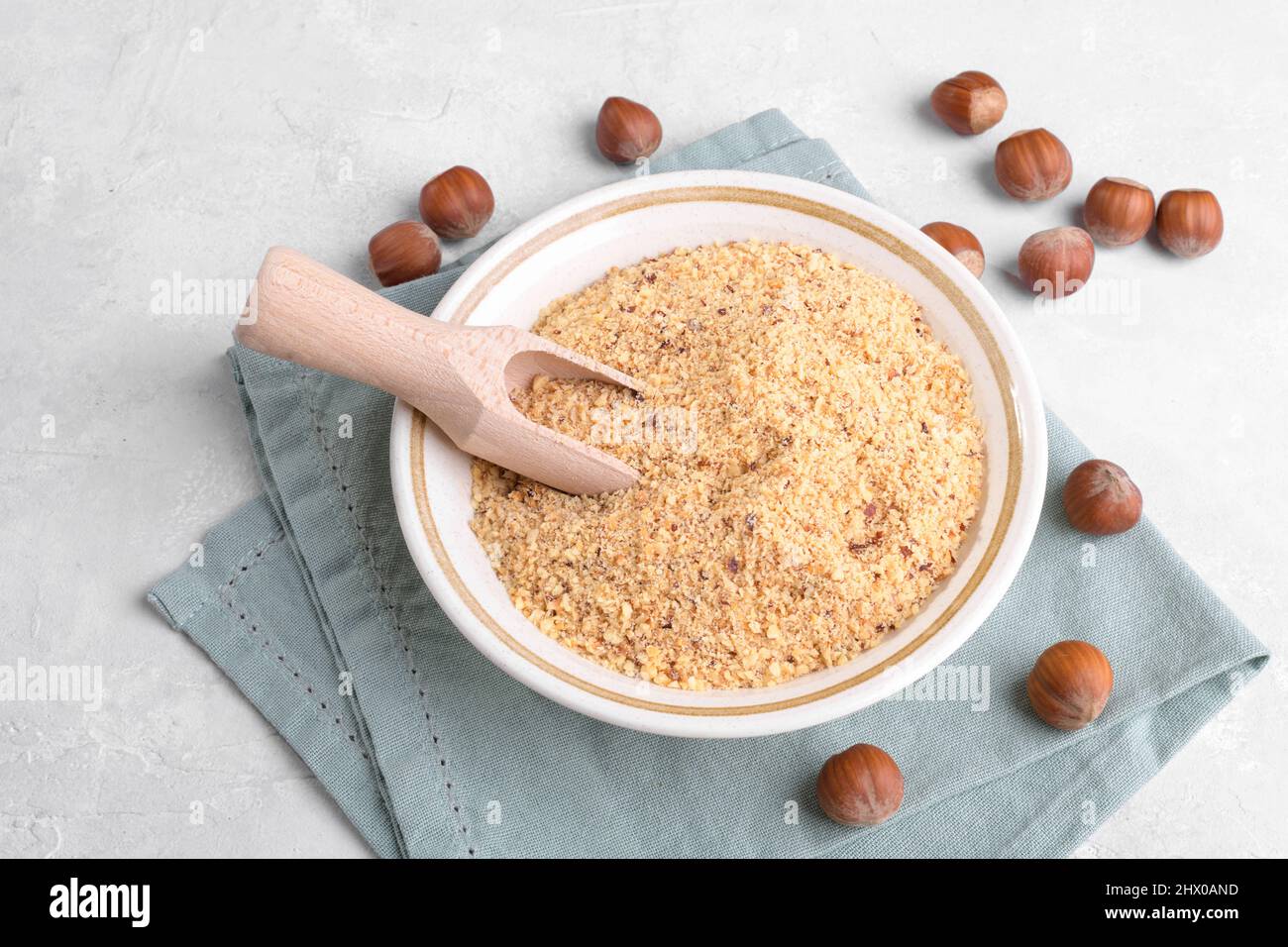 Raw Organic Ground Hazelnut Flour in a Bowl with whole nuts on grey ...