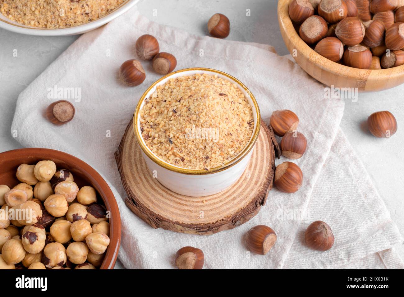 Raw Organic Ground Hazelnut Flour in a Bowl with whole nuts on grey ...