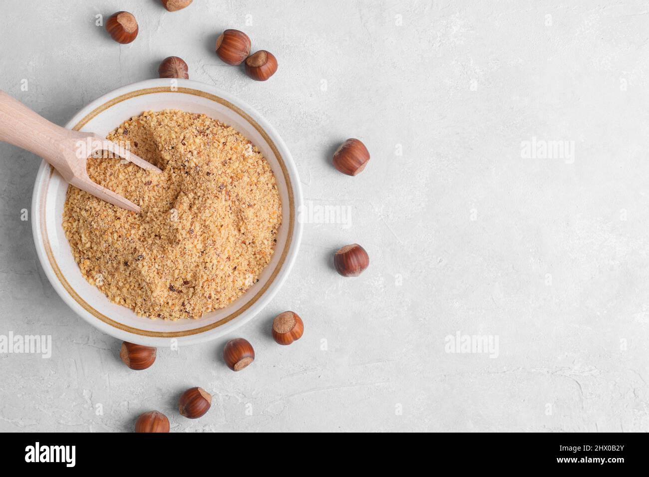Raw Organic Ground Hazelnut Flour in a Bowl with whole nuts on grey ...