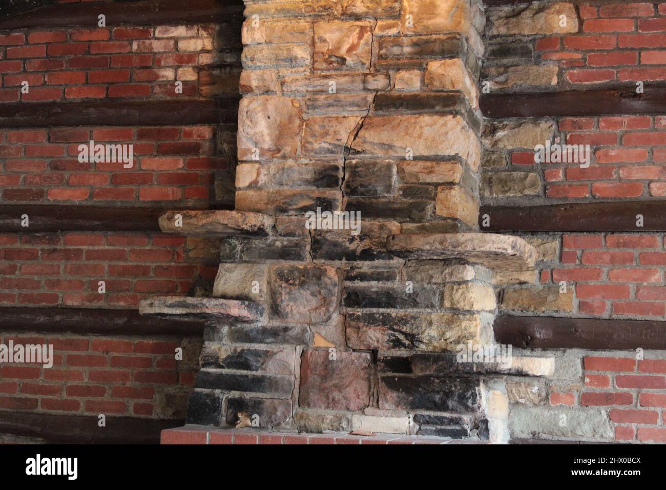 Stone chimney against brick and log wall Stock Photo - Alamy