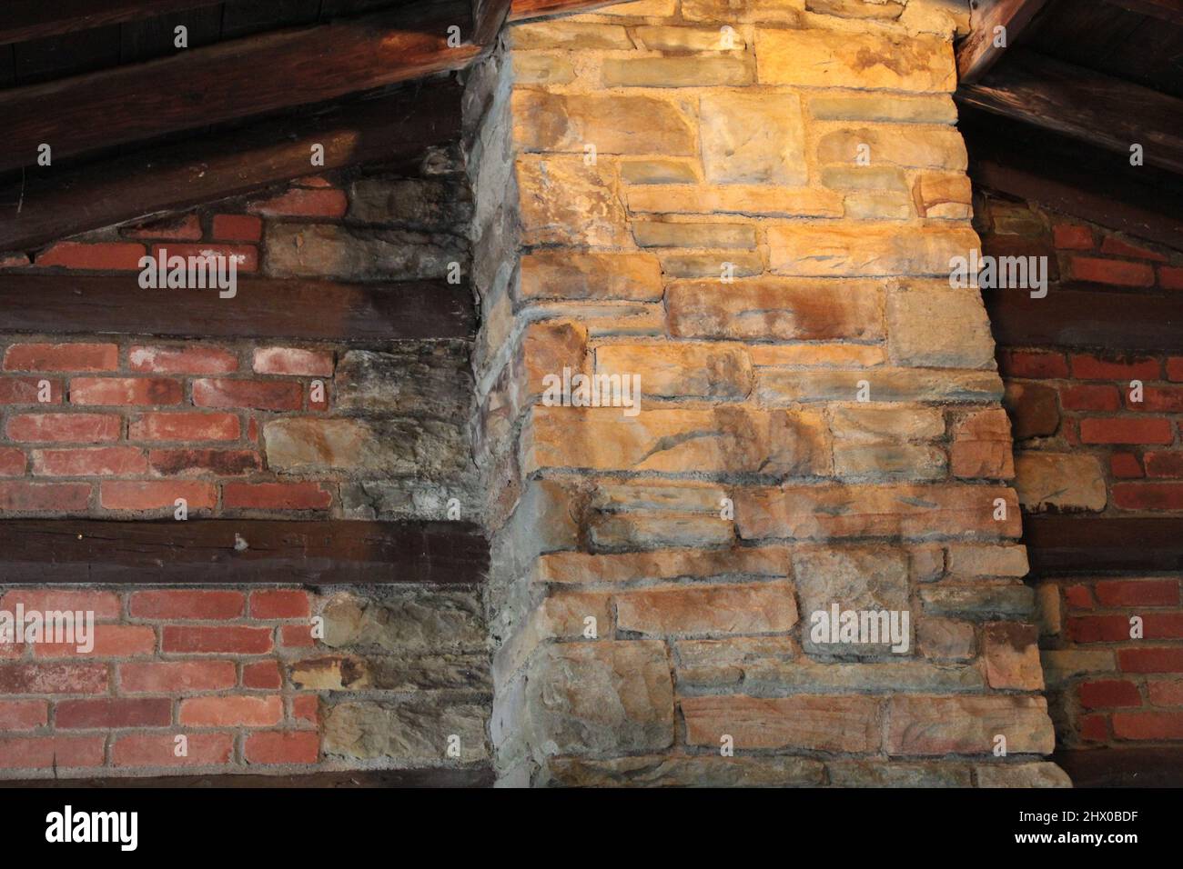 Stone chimney against brick and log wall Stock Photo - Alamy