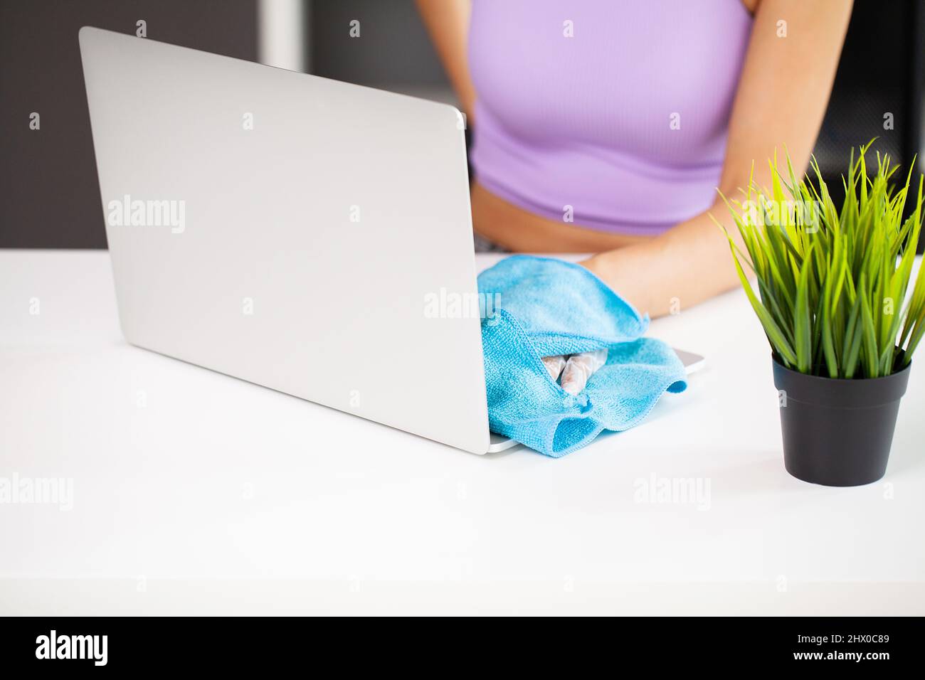 Woman wipes the laptop with a damp disinfectant wipe Stock Photo - Alamy