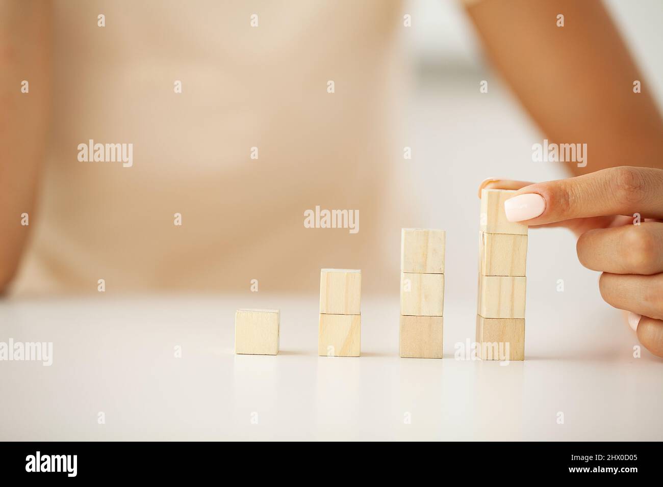 Hand arranging wood block stacking as step stair Stock Photo - Alamy