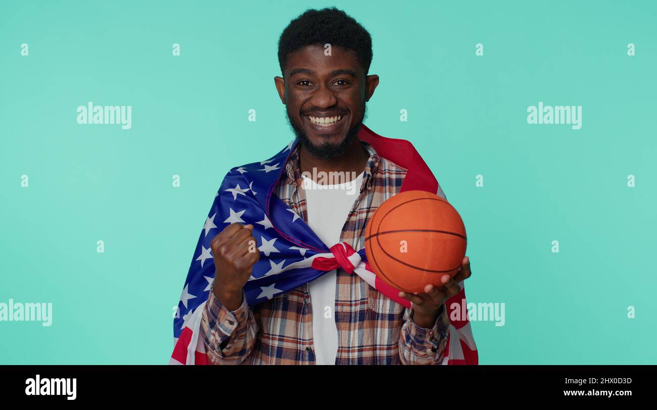 Bearded young man basketball fan holding American USA flag doing winner ...