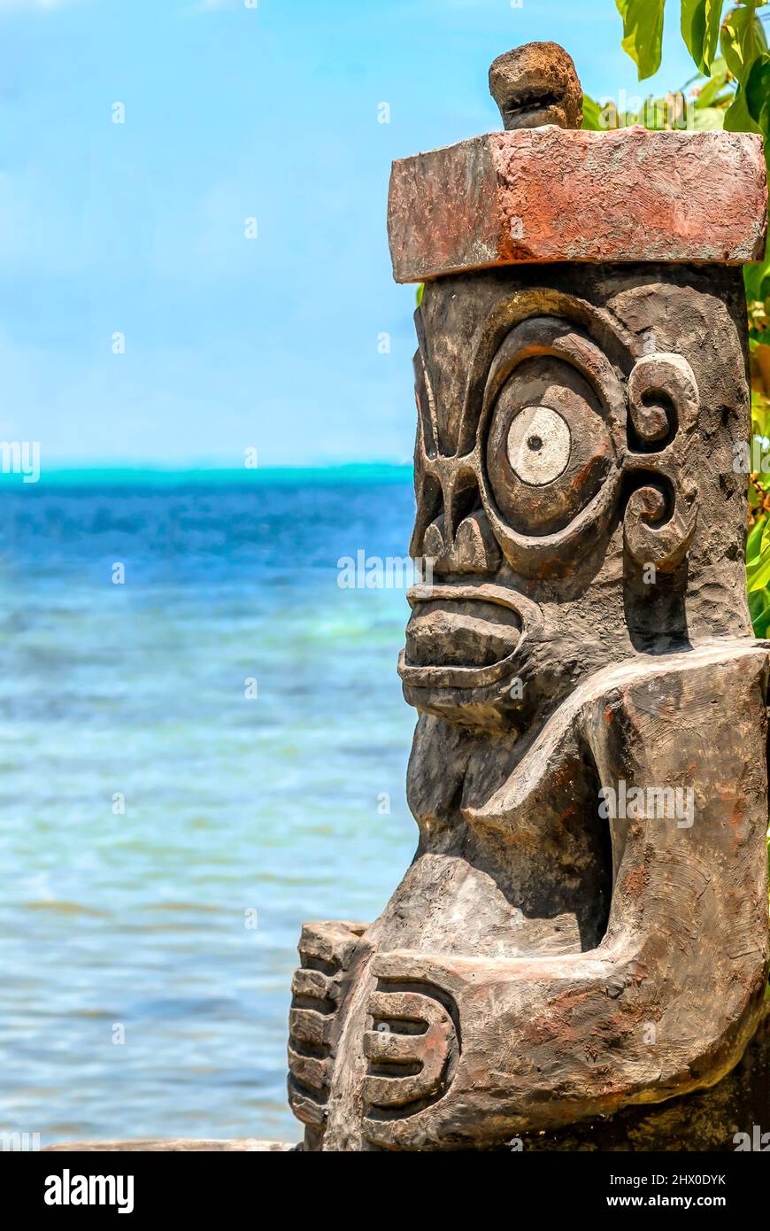 Traditional Tiki Statue in front of a beautiful palm lagoon on Bora ...