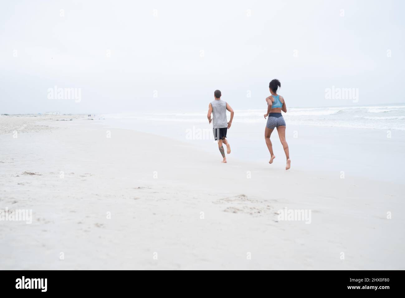 Getting their beach bodies ready for summer. Rearview shot of a young ...