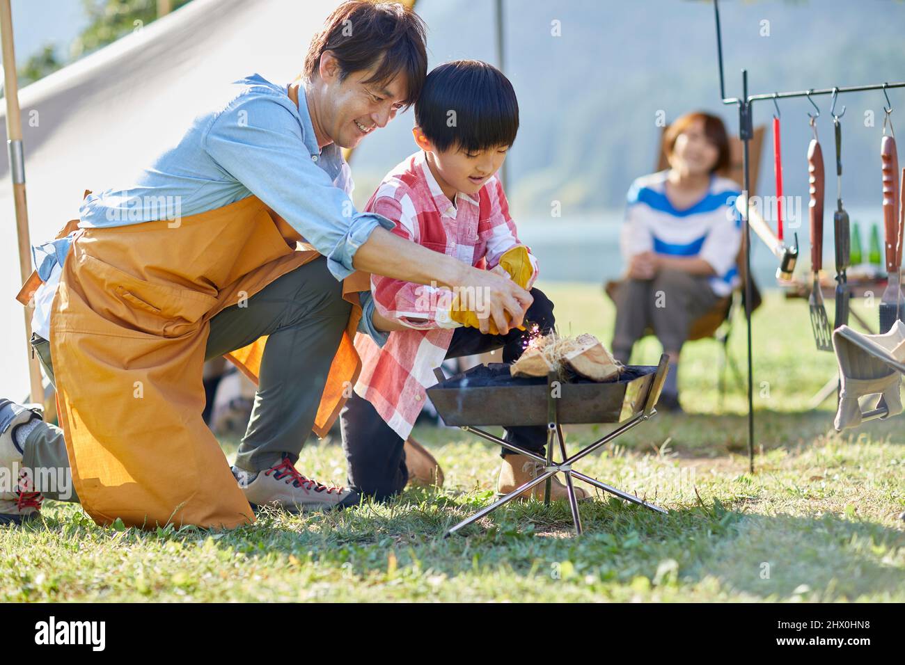 Japanese Parent And Child Making A Fire Stock Photo - Alamy