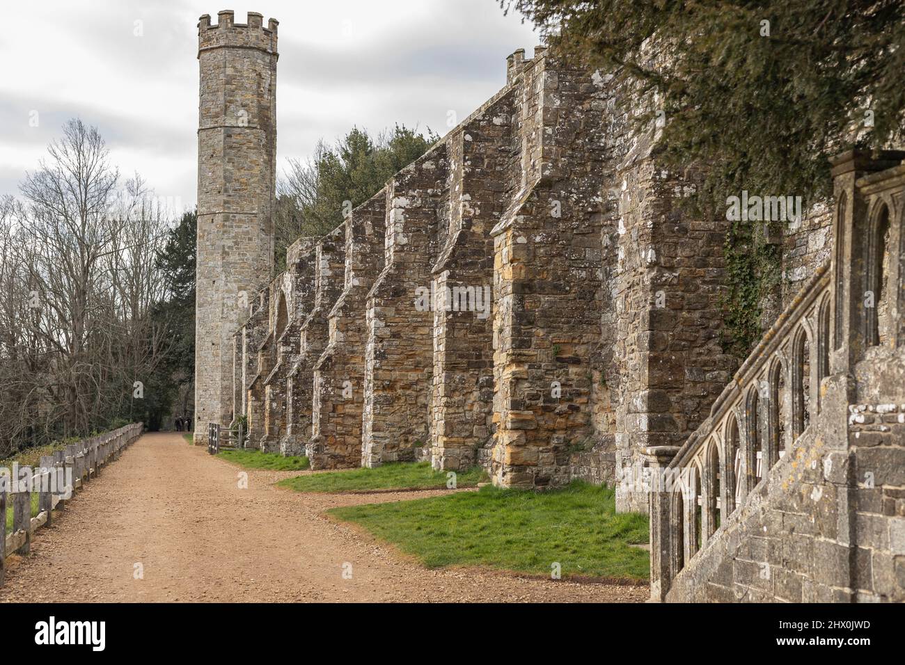 Looking down a sandy organge pathway at a tall pale coloured stone ...