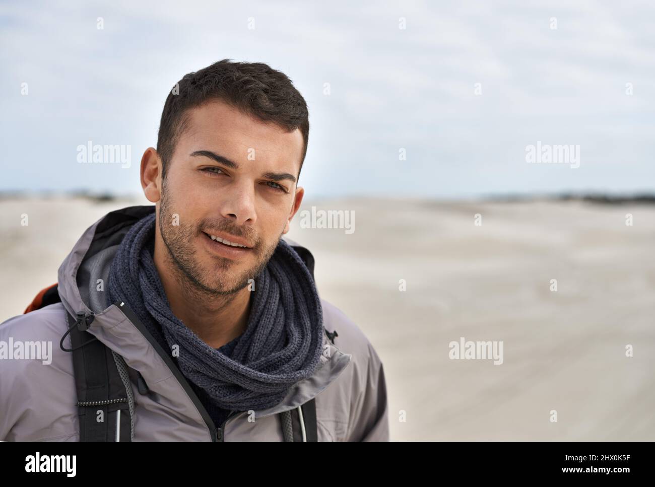 No climate is too much. Portrait of a young male hiker walking along ...